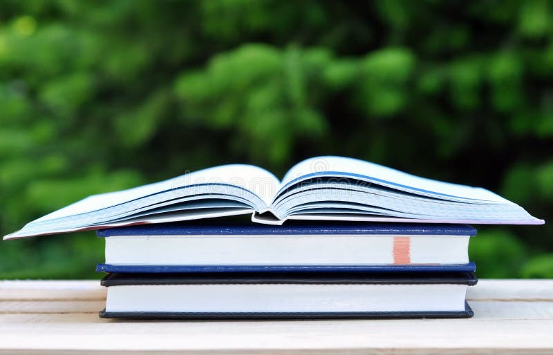 Books on Wooden Table on Nature Background and Open Book Stock Image ...