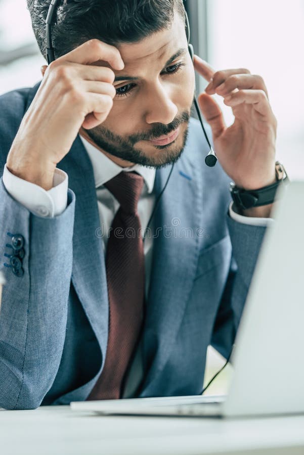 Bored Call Center Operator in Headset Looking at Laptop while Sitting ...
