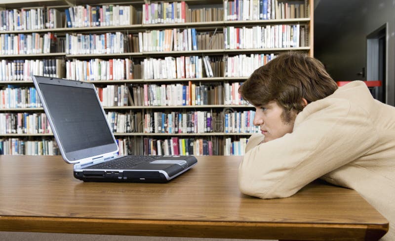 Bored College Student Looking at Laptop Stock Photo - Image of sitting ...