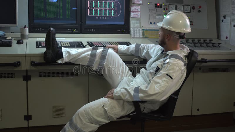 Bored Engineer Sitting in a Chair with His Foot on the Control Panel ...