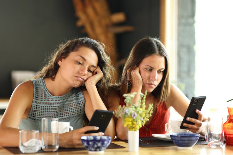 Bored Friends Checking Phones in a Restaurant Stock Photo - Image of ...