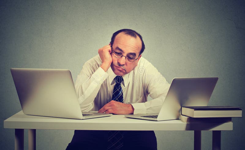 Bored Man Sitting in Front of Two Laptop Computers Stock Photo - Image ...