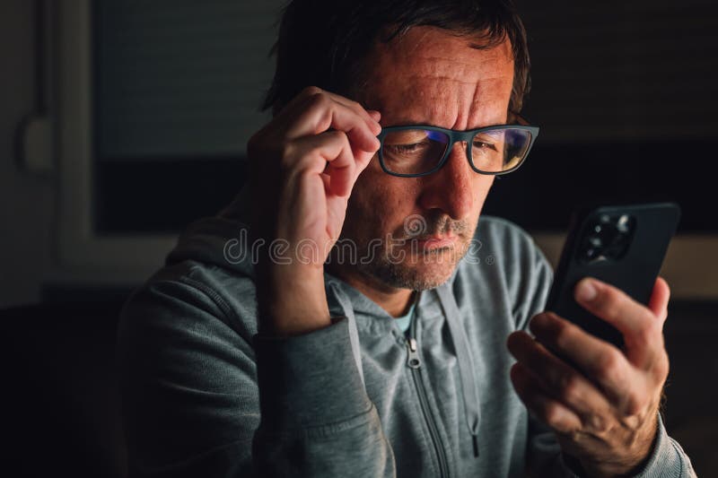 Bored Man Using Smartphone Late at Night, Browsing the Internet or ...
