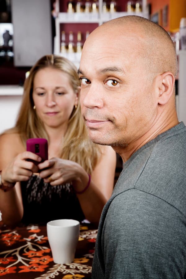 Bored Man with Woman on Cell Phone Stock Image - Image of hand, drink ...