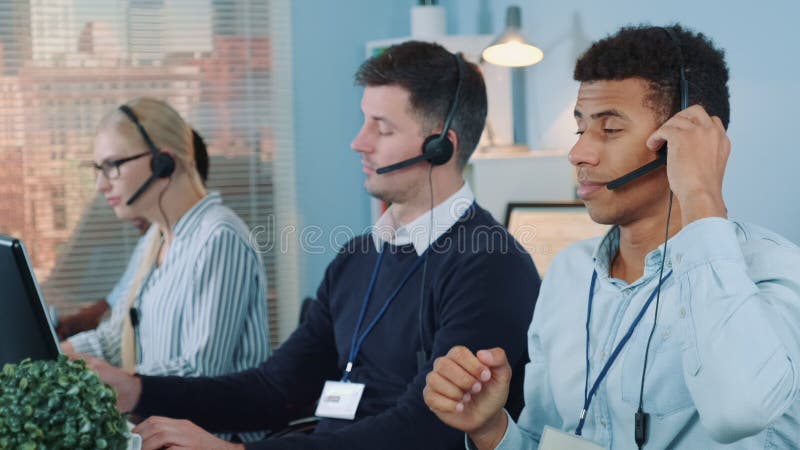 Bored Multiethnic Customer Support Operator Waiting for Telephone Call ...