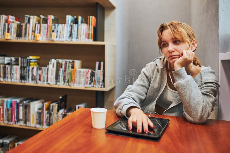 Bored Student Learning in University Library. Young Woman Listening To ...