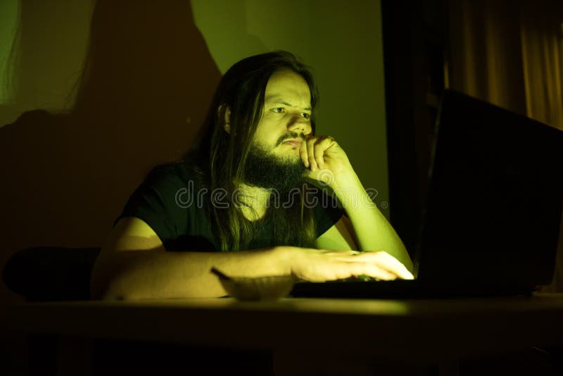 Bored User is Looking at His Computer Browsing through the Internet ...