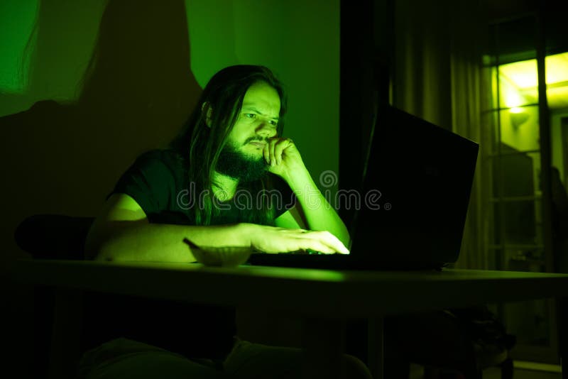 Bored User is Looking at His Computer Browsing through the Internet ...