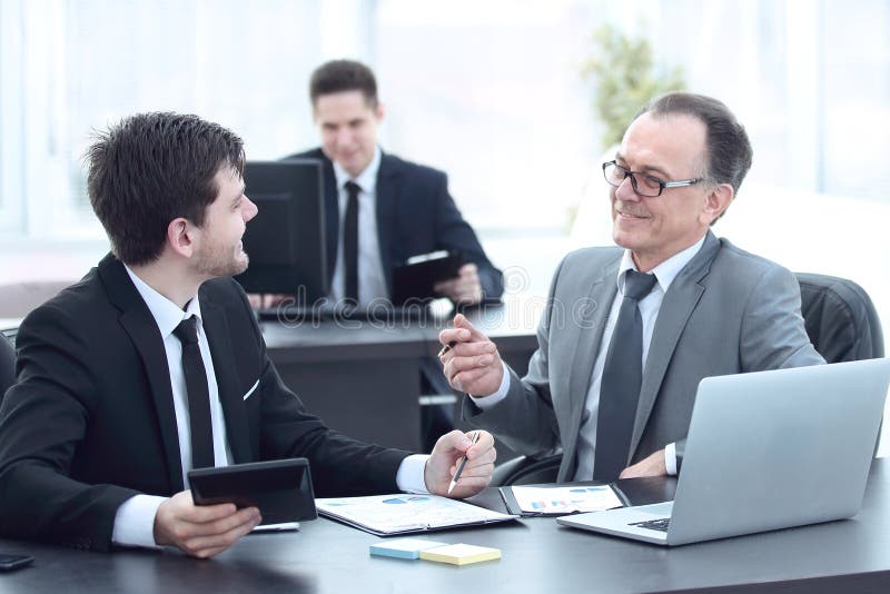 Boss and Employee Discussing the Document Sitting at the Desk in the ...