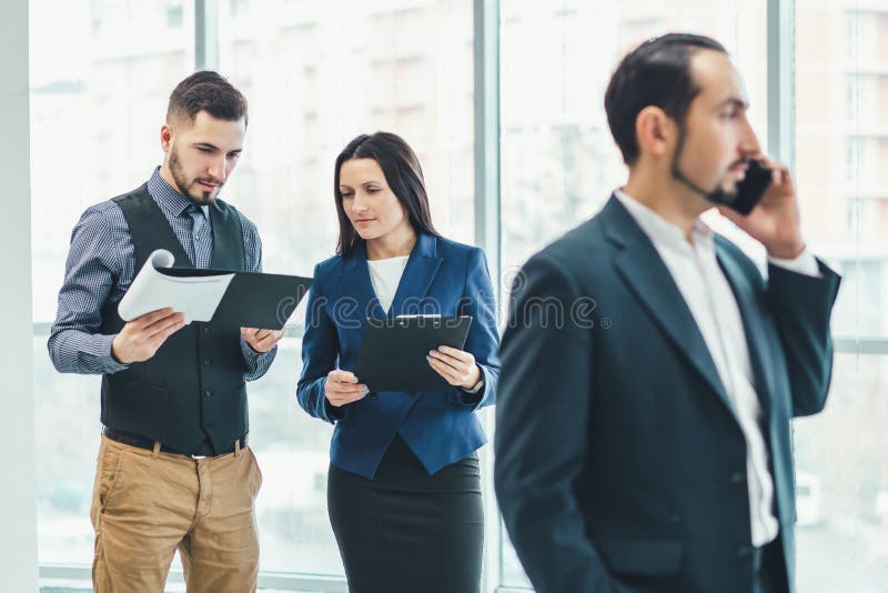 Boss on the Forefront is Talking on Phone. Two Employees in Suits ...