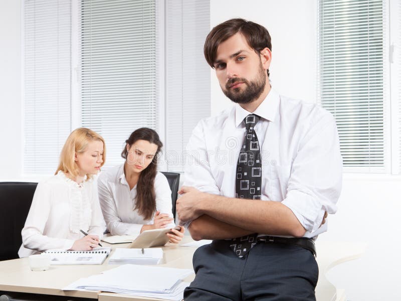 Boss in Front Looking at Camera with Team on Background Stock Photo ...