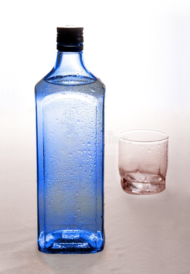 Botella azul con ginebra foto de archivo. Imagen de blanco - 13021430