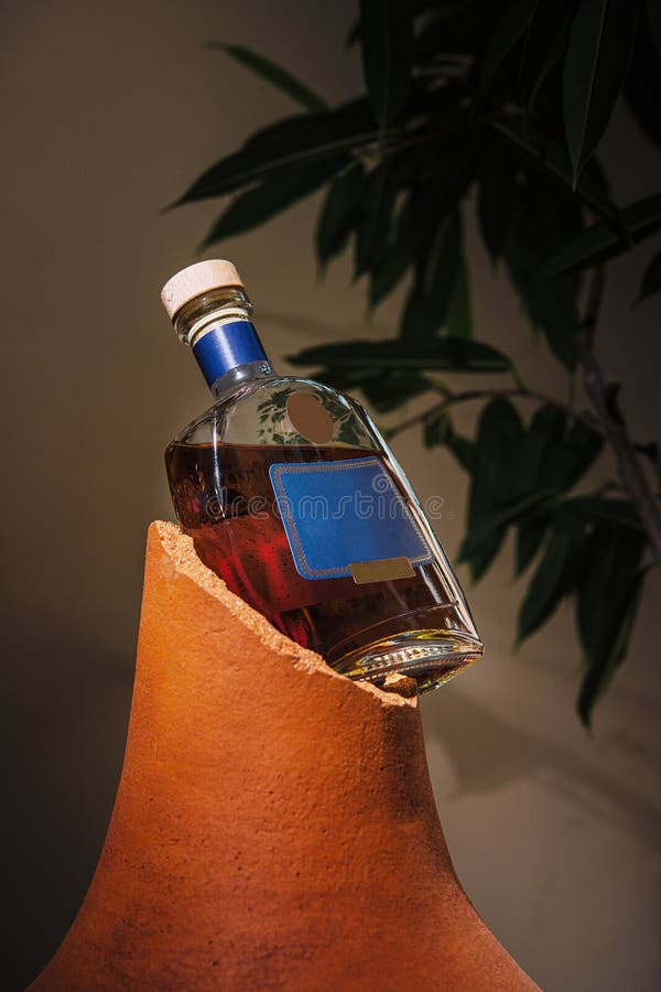 Bottle of Cognac Balancing Precariously on Edge of Broken Clay Pot ...