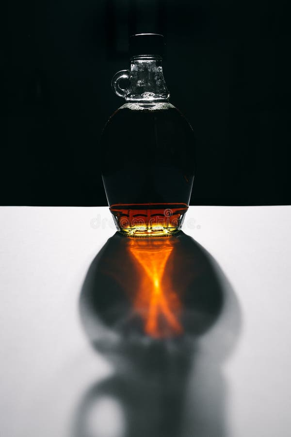 Bottle of Dark Brown Canadian Maple Syrup Reflecting on White ...