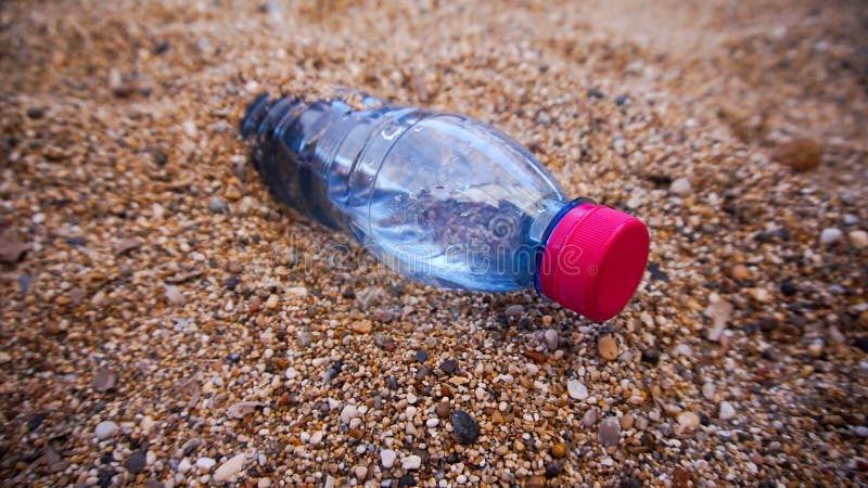 Plastic bottle in the sand stock photo. Image of clean - 99586788