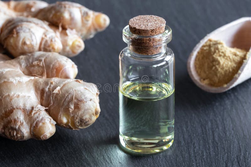 A Bottle of Ginger Essential Oil with Ginger Root and Powder Stock ...