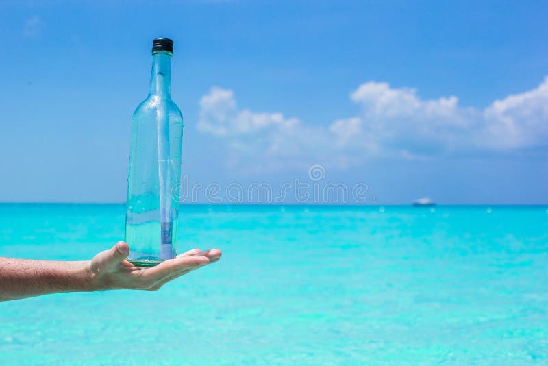 Bottle with a Message in the Hand Background Blue Stock Photo - Image ...