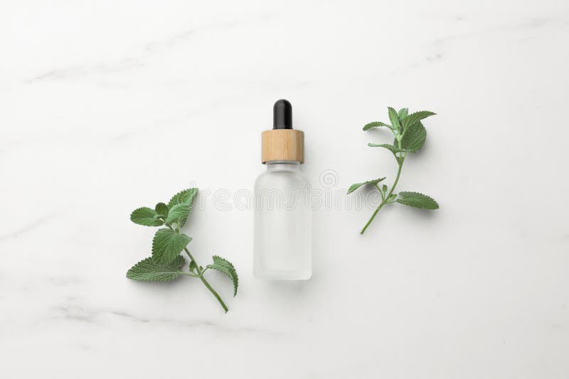 Bottle of Mint Essential Oil and Fresh Herb on White Marble Table, Flat ...