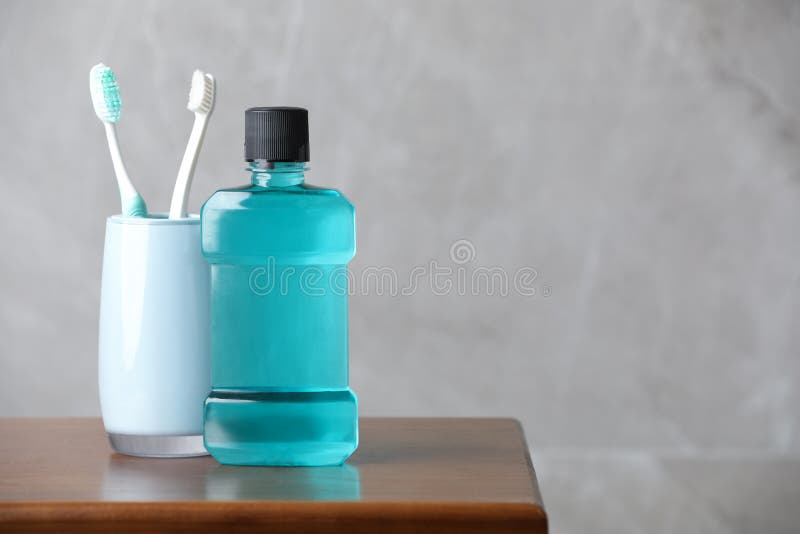 Bottle of Mouthwash and Toothbrushes on Wooden Table, Space for Text ...