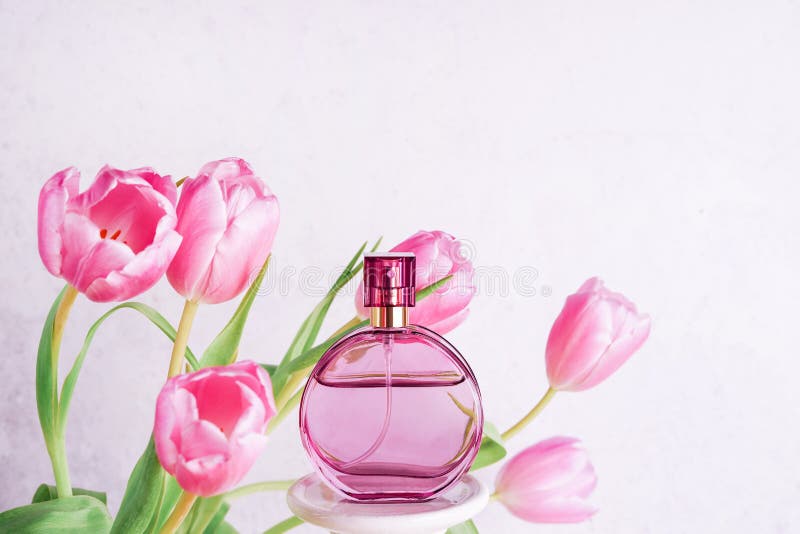 Bottle of Perfume with Flowers Pink Tulips on White Concrete Background ...
