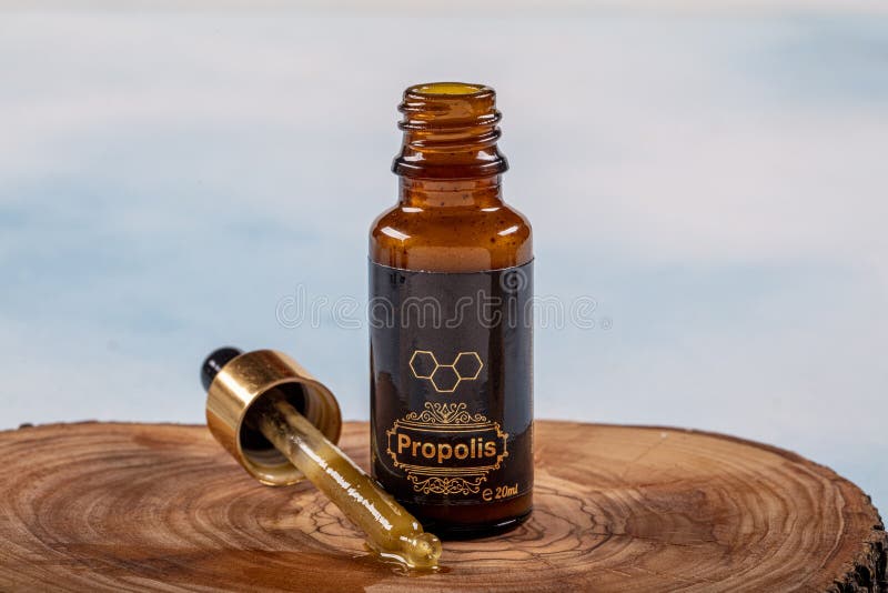 A Bottle of Propolis on Piece of Wood Propolis Drop Oil Drop Falling ...