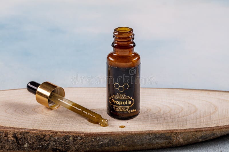 A Bottle of Propolis on Piece of Wood Propolis Drop Oil Drop Falling ...