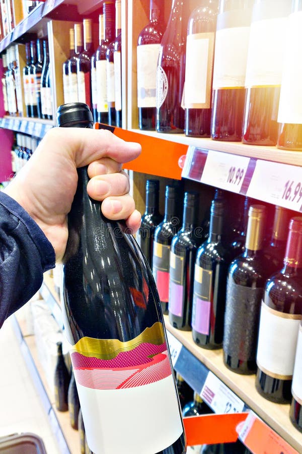 Bottle of red wine on hand stock photo. Image of store - 310775876