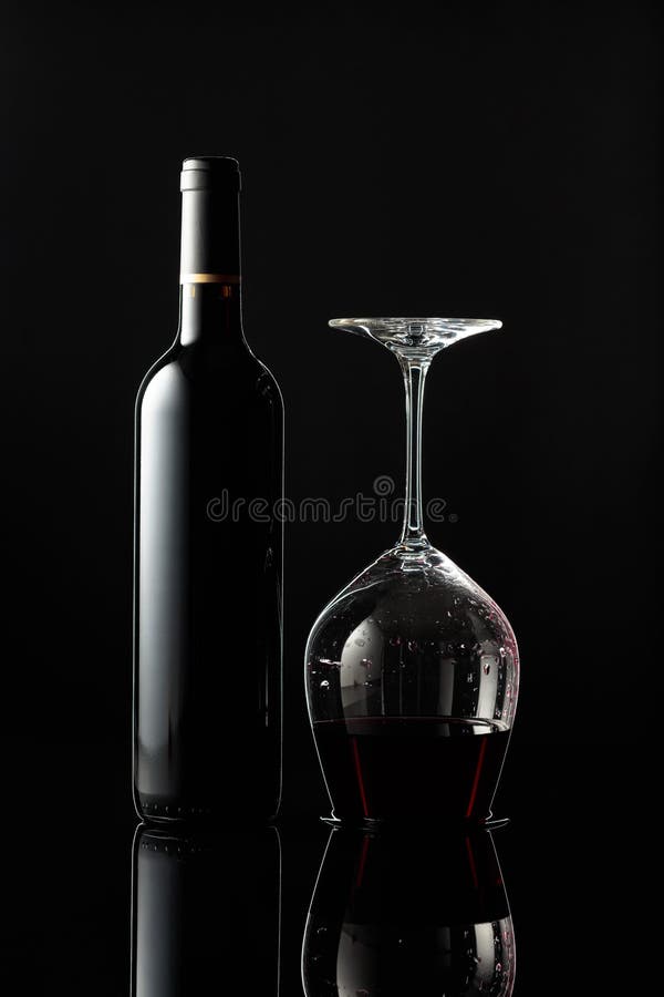 Bottle of Red Wine and an Inverted Glass with Wine on a Black ...