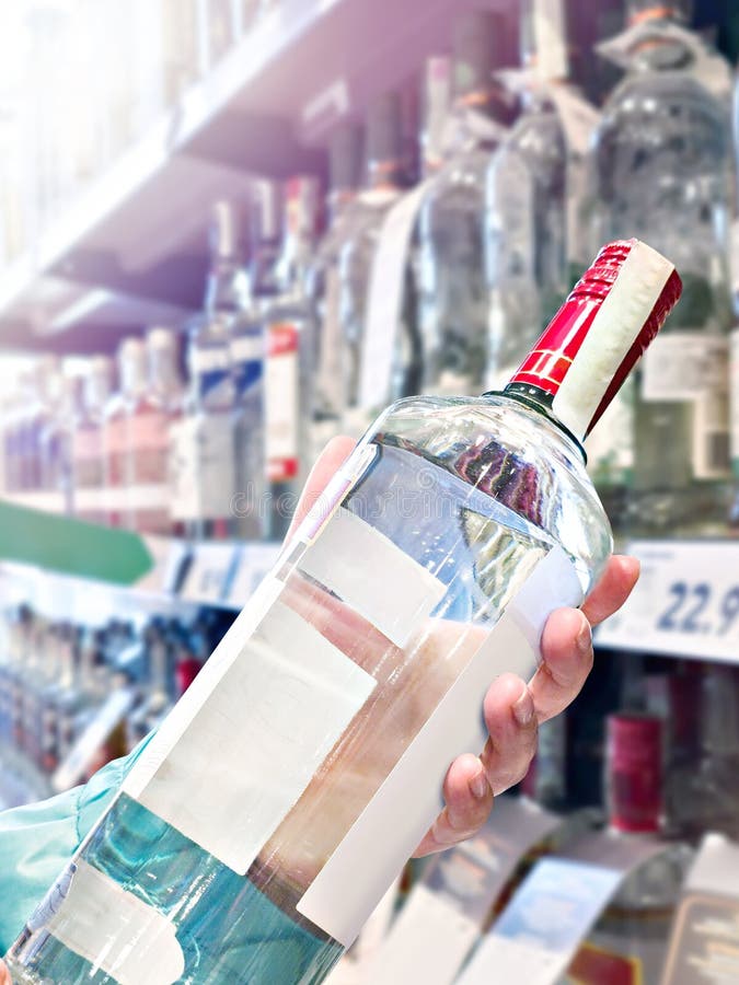 Bottle of vodka in hand stock photo. Image of selection - 352431022