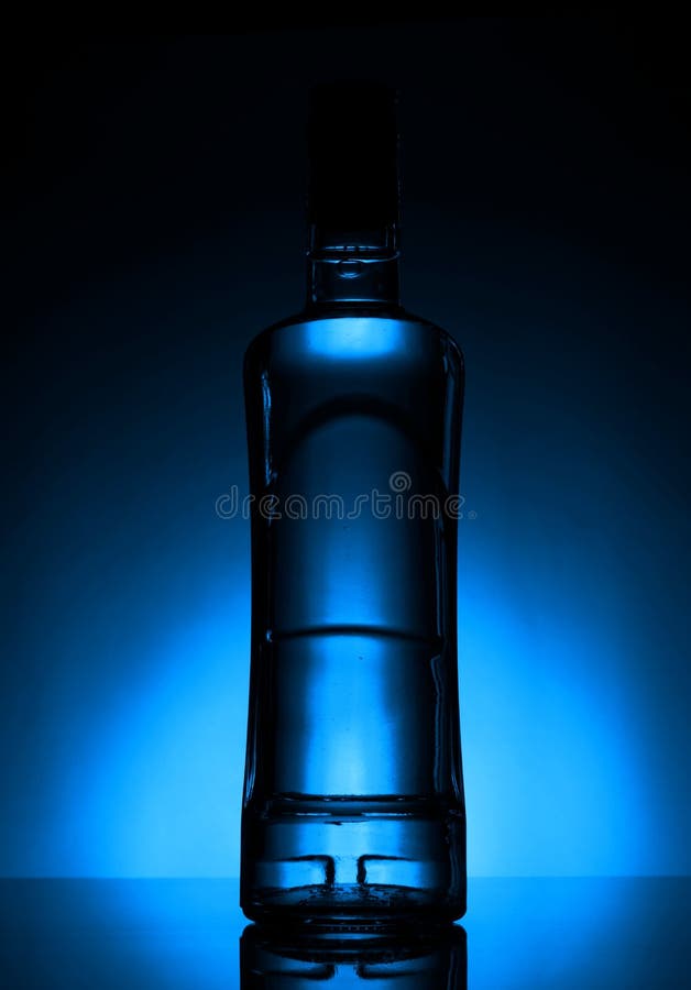 Bottle of Vodka Lying with Glass Lit with Blue Backlight Stock Photo ...