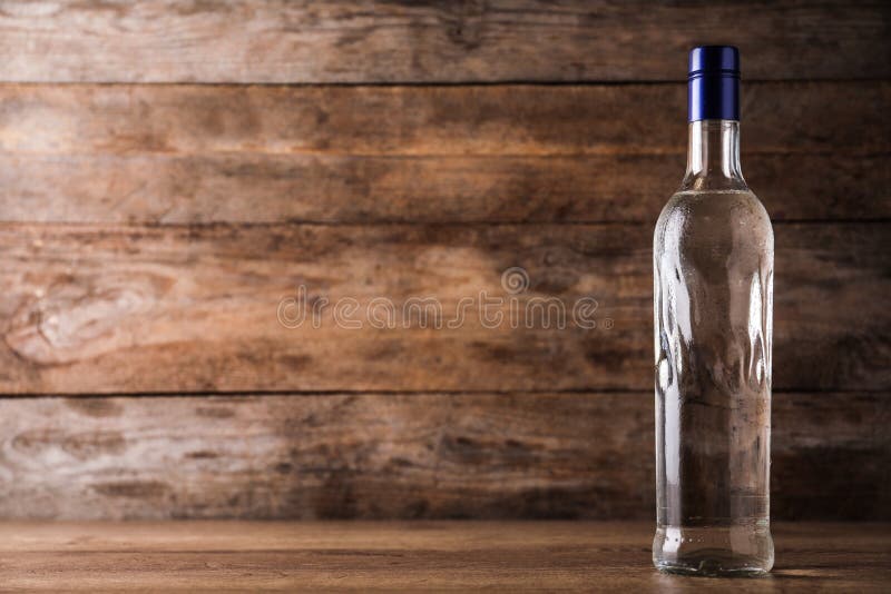 Bottle of Vodka on Table Against Background. Space for Text Stock Photo ...