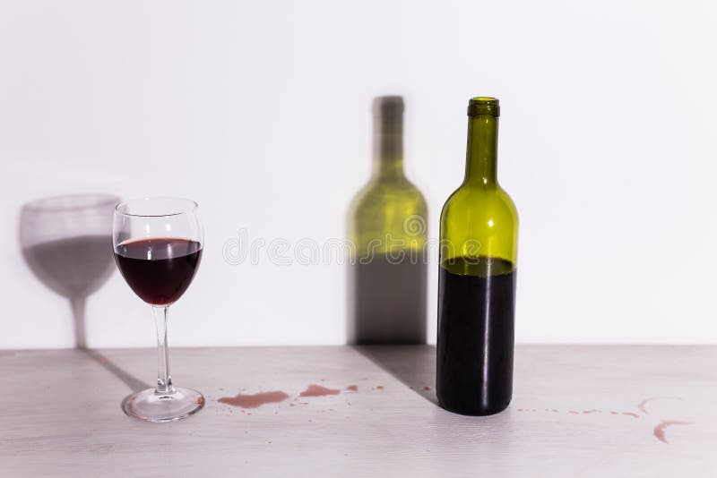 Bottle with Wine and Glass, Red Puddle of Wine on the Table. Cleaning ...