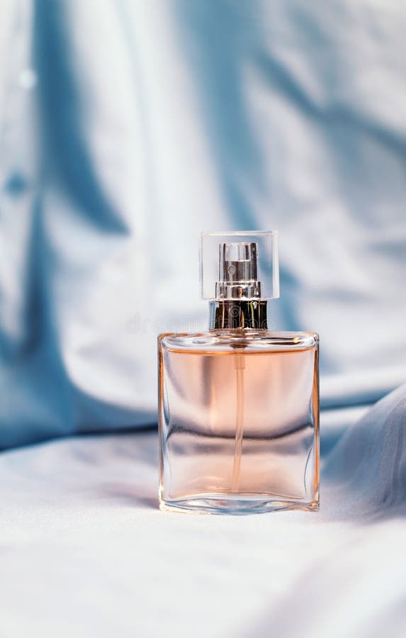 A Bottle of Women`s Fragrant Perfume on a Silk Textured Fabric ...