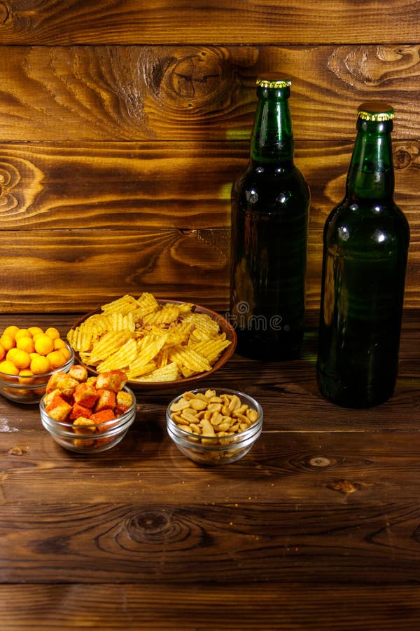 Bottles of Beer and Various Snacks for Beer on Wooden Table Stock Photo ...