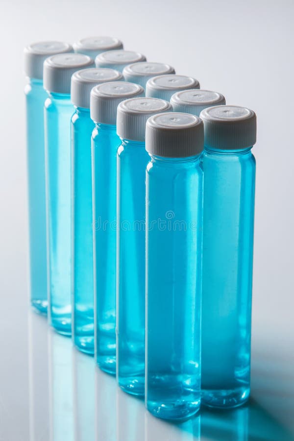 Bottles with blue liquid stock image. Image of injection - 57775345