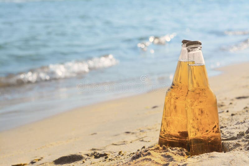 Bottles of Cold Beer on Sandy Beach Near Sea, Space for Text Stock ...