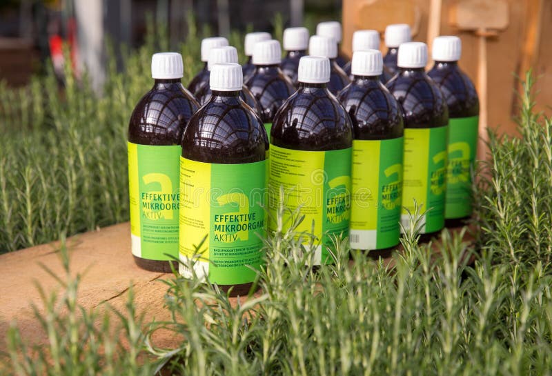 Bottles of Effective Microorganisms in Garden Setting with Green Labels ...