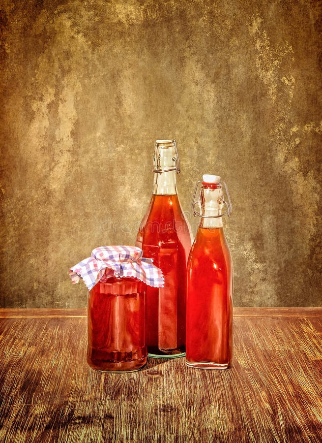 Bottles Filled with Yellow Syrup and Jam on Kitchen Table Stock Image ...