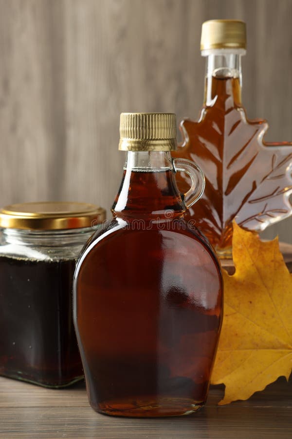 Bottles and Jar of Tasty Maple Syrup on Wooden Table Stock Image ...