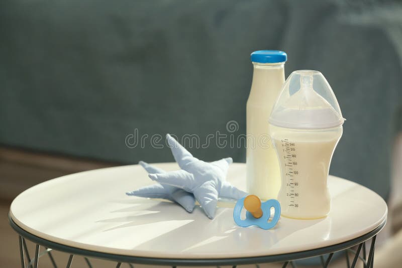 Bottles with Milk for Baby, Soother and Toys on Table Stock Image ...