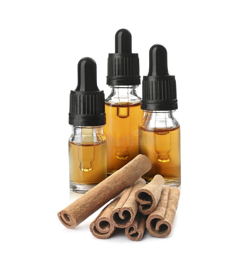Bottles of Natural Essential Oil and Dry Cinnamon Sticks on White ...