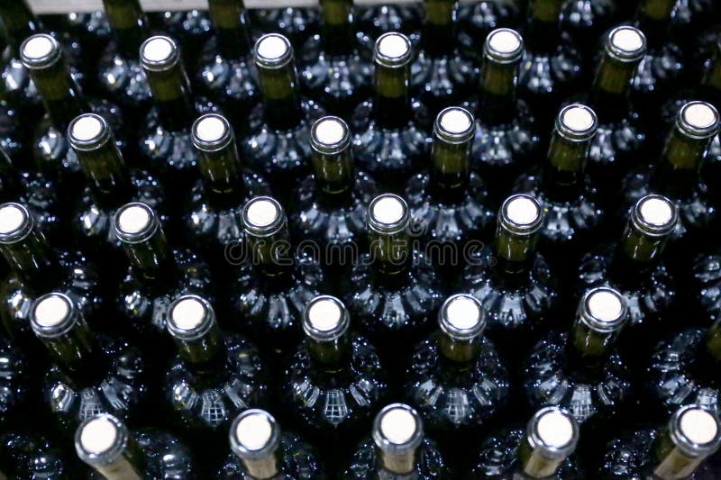 Bottles in a Row at Wine Cellar. Stacked Up Wine Bottles in the Cellar ...