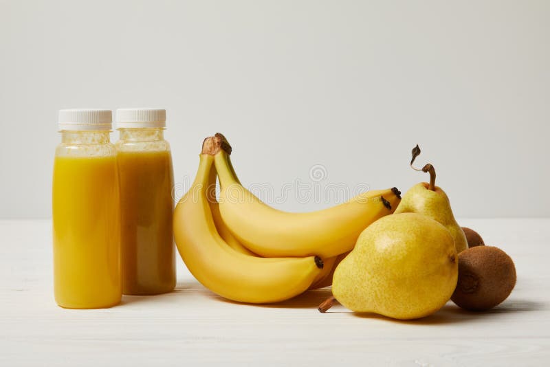 Bottles with Yellow Smoothies with Bananas, Pears and Kiwis on White ...