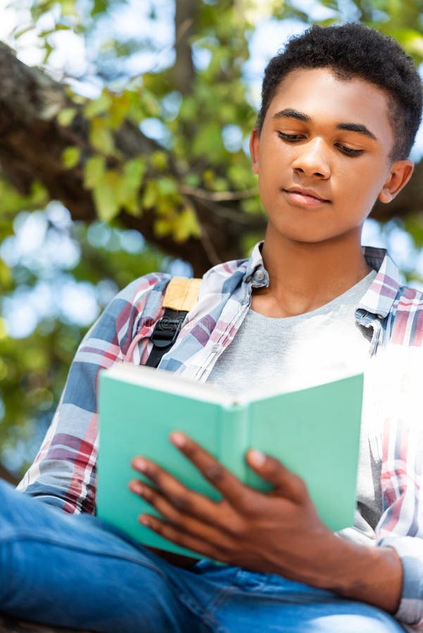 Bottom View of Focused Teen Student Reading Book Stock Image - Image of ...