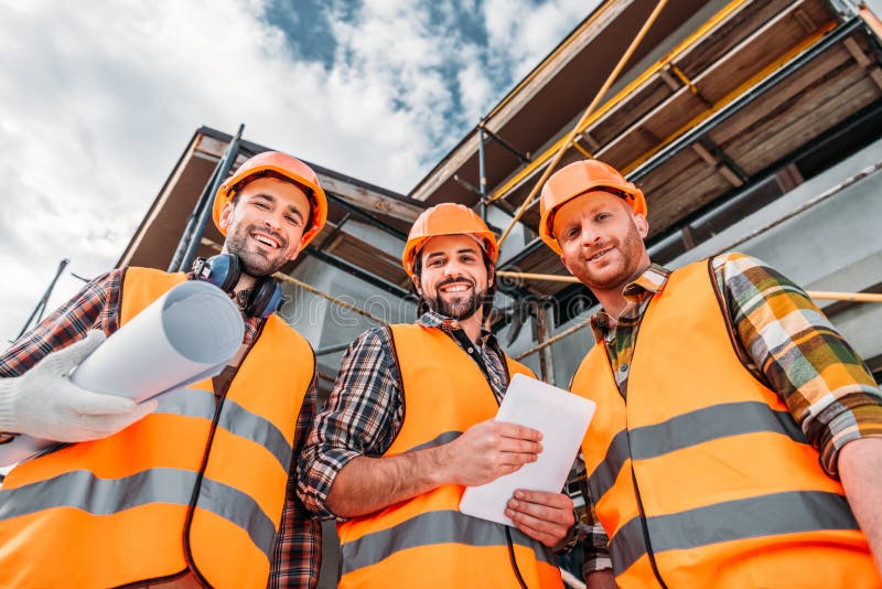 Bottom View of Group of Builders with Blueprint and Tablet Looking at ...