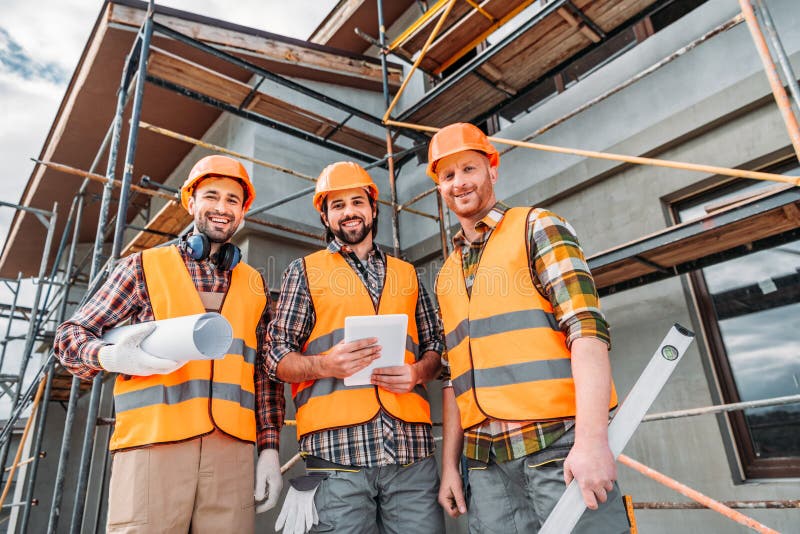Bottom View of Group of Smiling Builders with Blueprint and Tablet ...