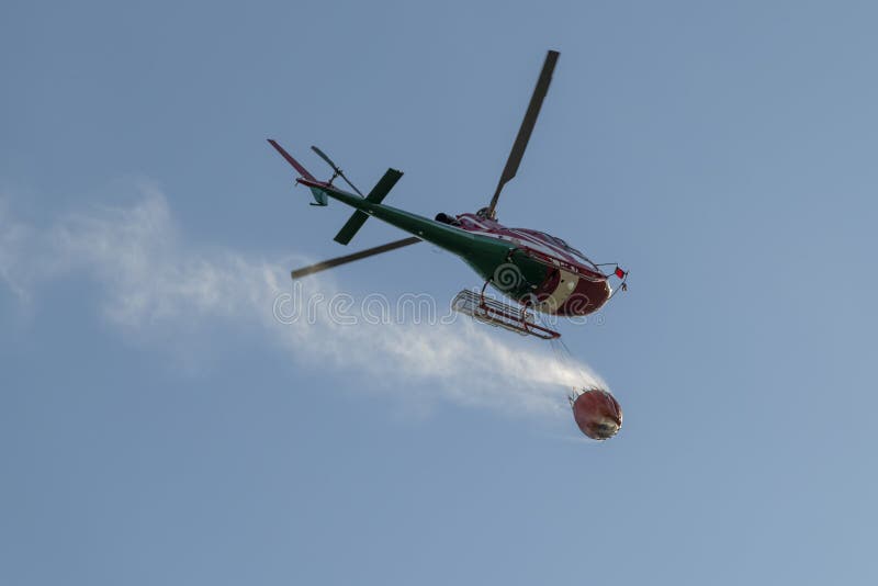 Bottom View of a Helicopter Carrying a Container of Water To Put Out a ...