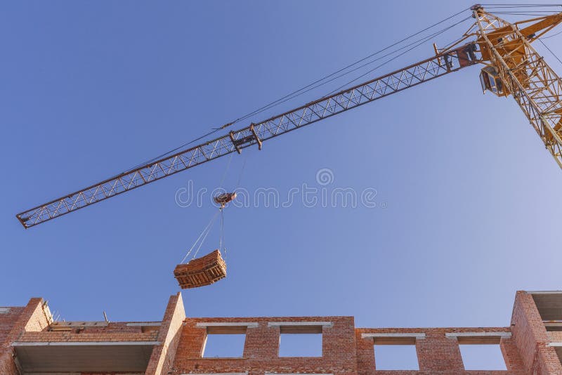 Bottom View of a Tall Tower Crane Near a Brick Building Stock Photo ...
