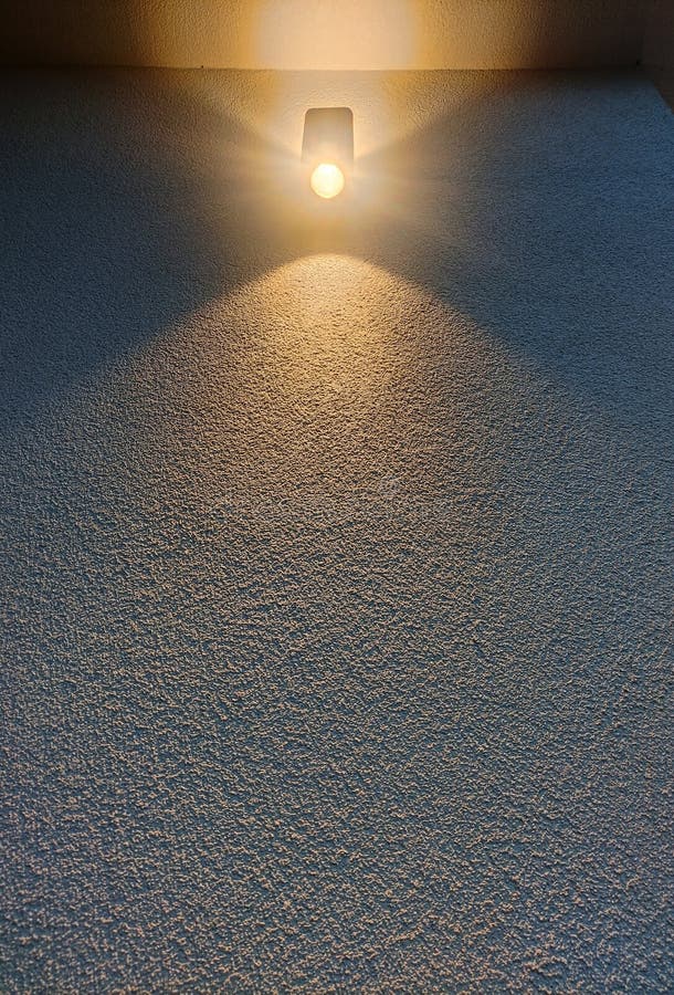 Bottom View of a Wall Light Bulb Illuminating a White Wall in Yellow ...