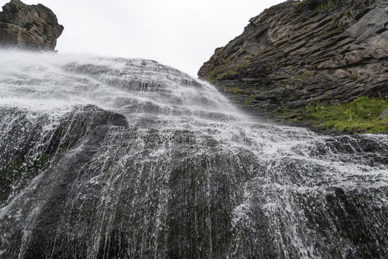 Bottom View of Water Jets Falling Down from Top of High Rocky Mountains ...